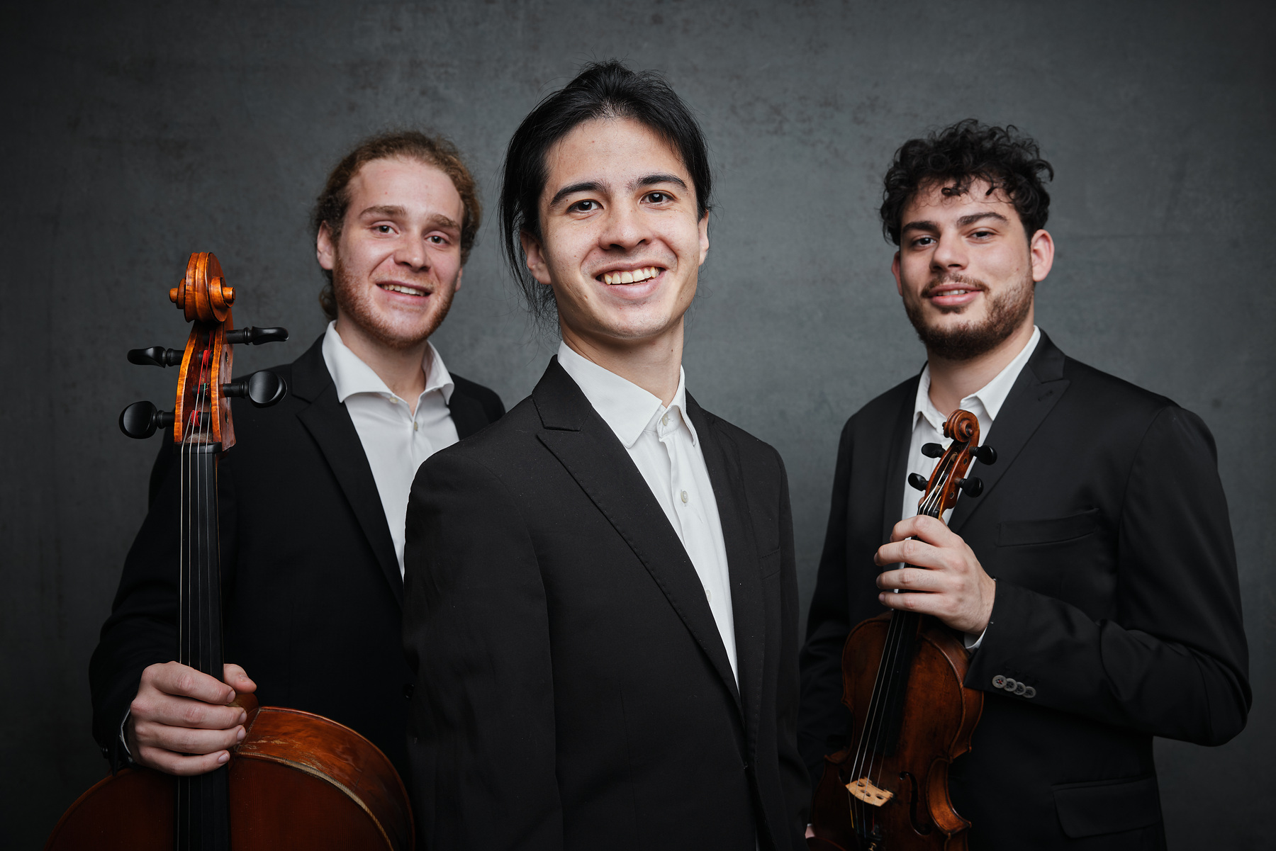 Die drei Musiker des Trio Concept in eleganten Anzügen, einer mit Cello ...
